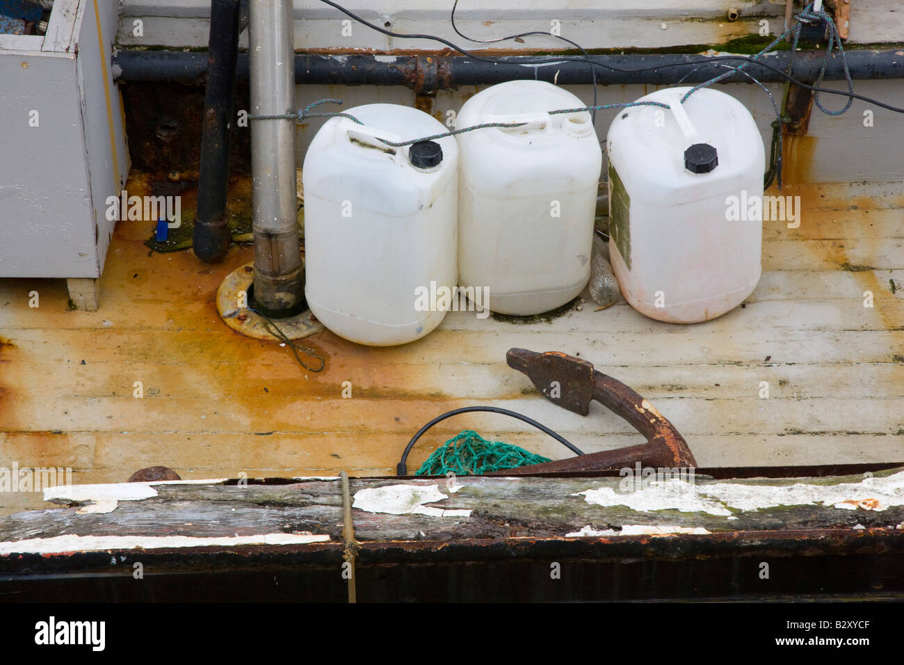 Three plastic containers and rusty anchor on the deck of a boat Stock ...