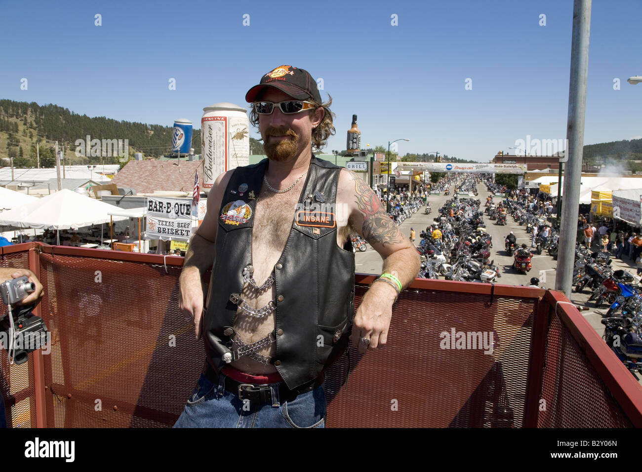 Motorcyclist posing on Main Street with overview of 67th Annual Sturgis ...