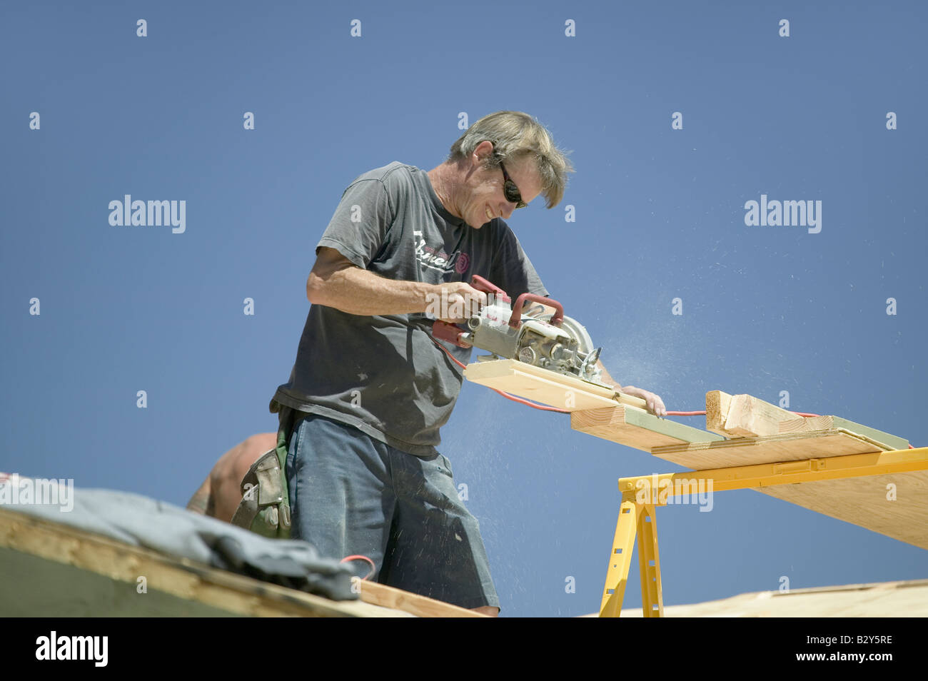 Carpenter sawing board on roof on new house construction, Ojai ...