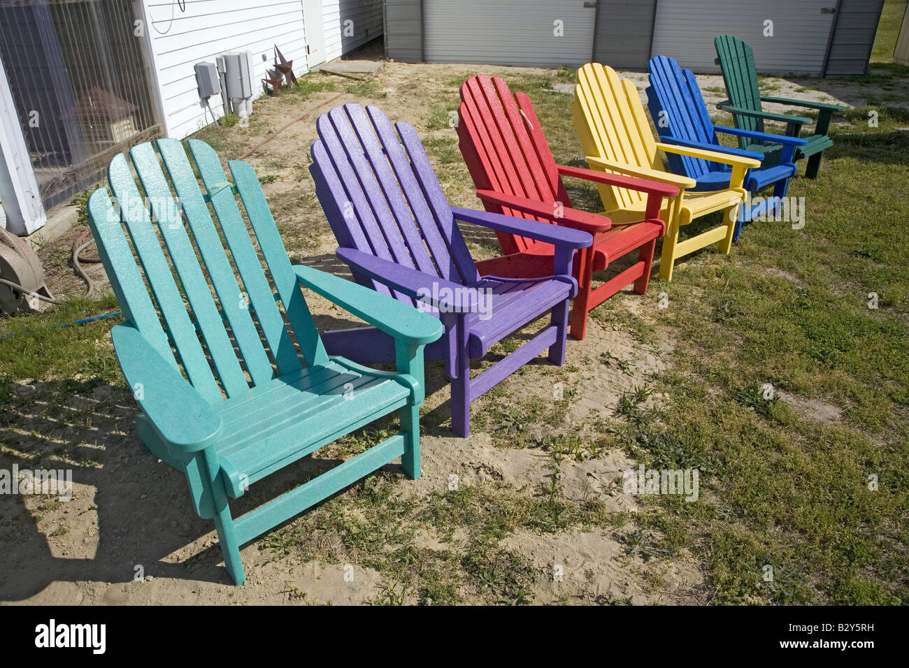 Rainbow colored wooden chairs, known as "Maine Chairs," standing in a ...