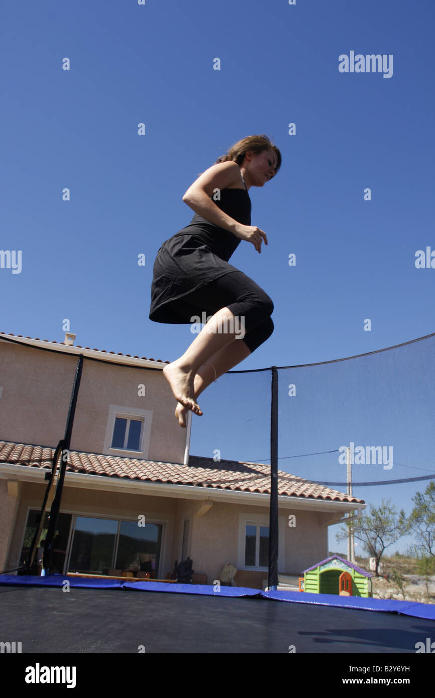Girl jumping on trampoline, blue sky, vertical format.85084 Parnoufete ...