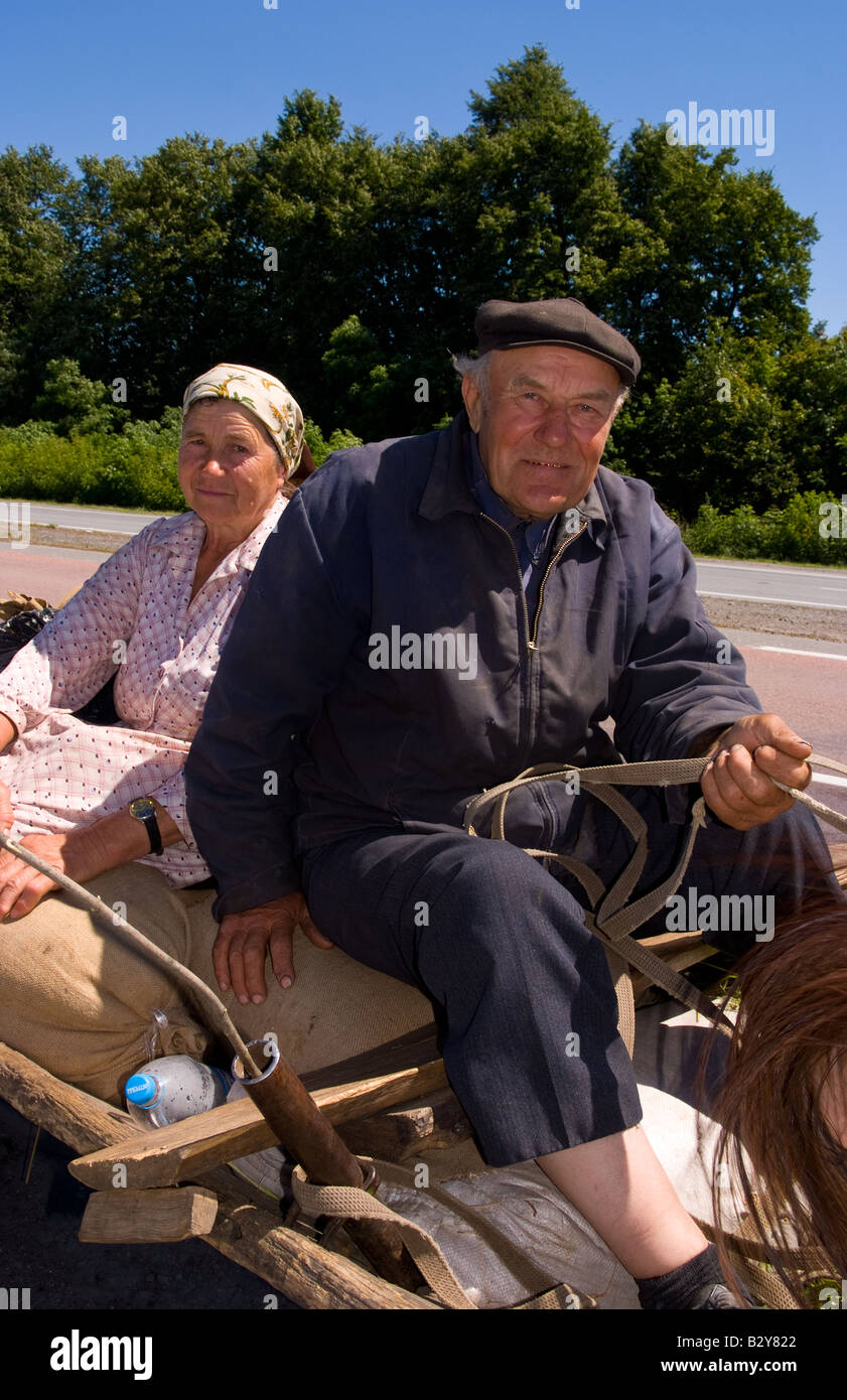 Poor farming couple riding on horse carriage on road from Kiev to Lviv ...