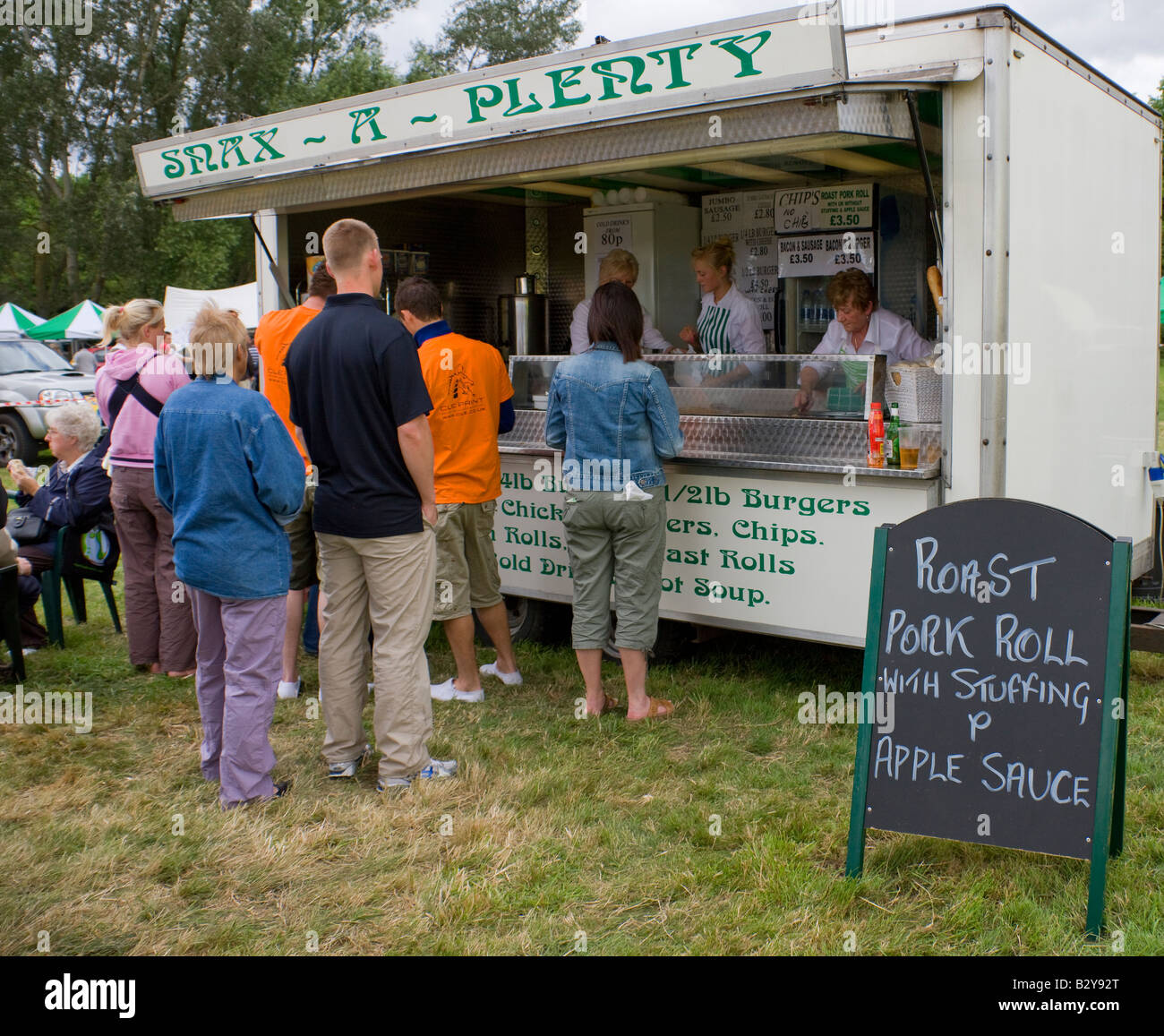 People queueing for lunch time food at a snack bar advertising Roast ...