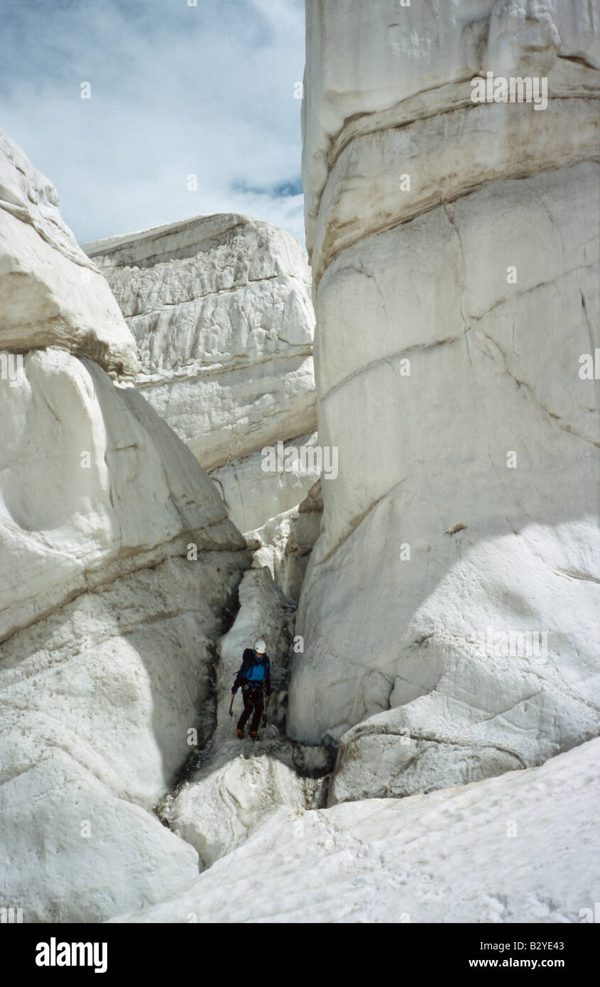 Climber in a slot between massive seracs on Bashkara glacier in Adil-Su ...