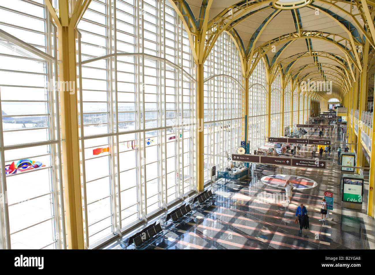 Passengers walk through the airport terminal at Ronald Reagan ...