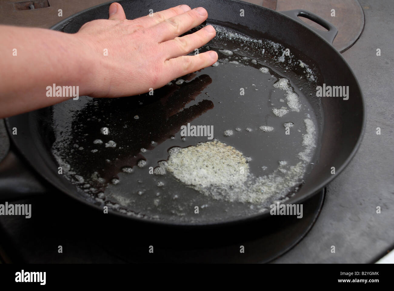 A hand feel the heat of the frying pan Stock Photo - Alamy