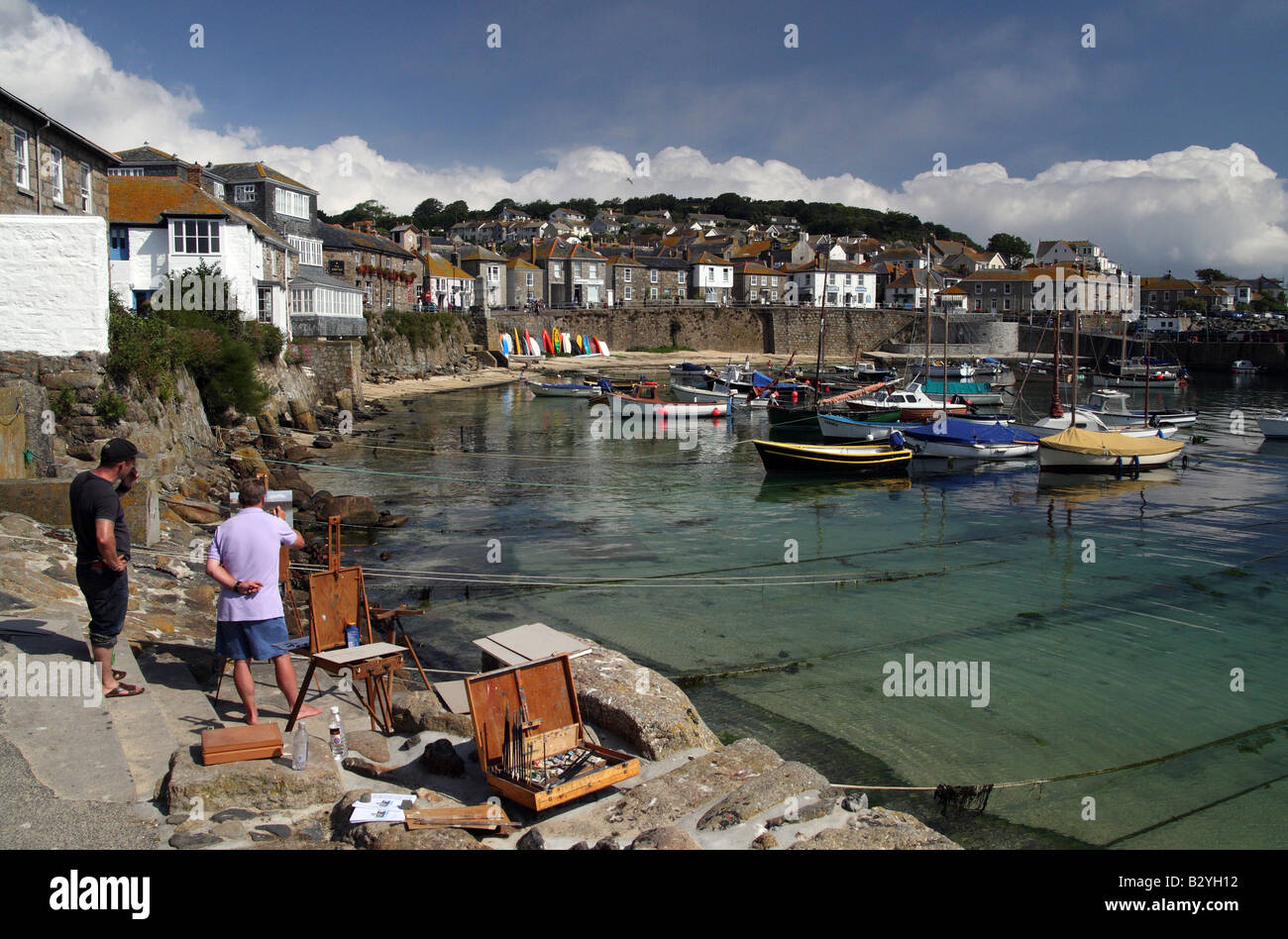 An artist painting the historic fishing village of Mousehole in ...