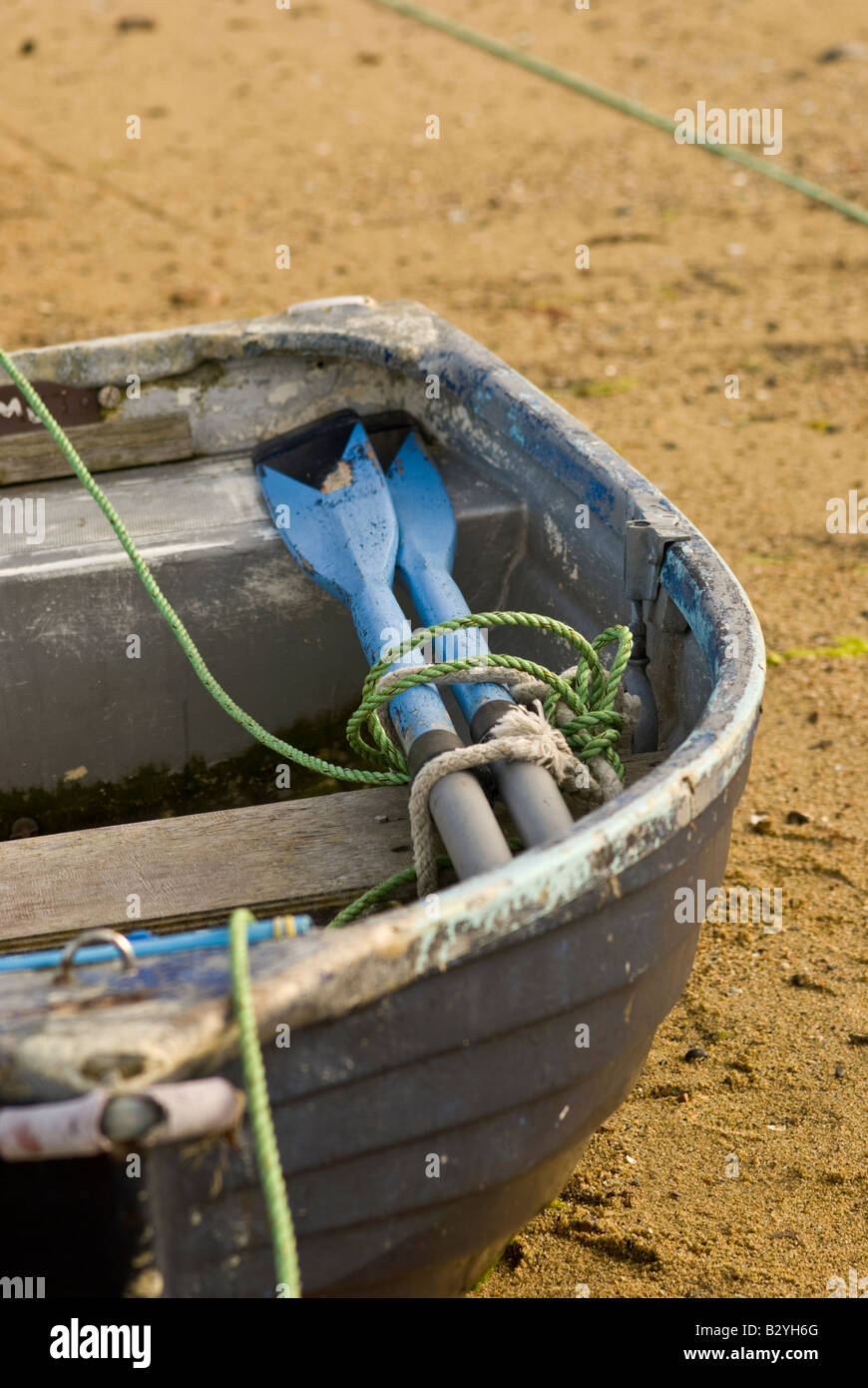 An old beached rowing boat with blue oars Stock Photo - Alamy
