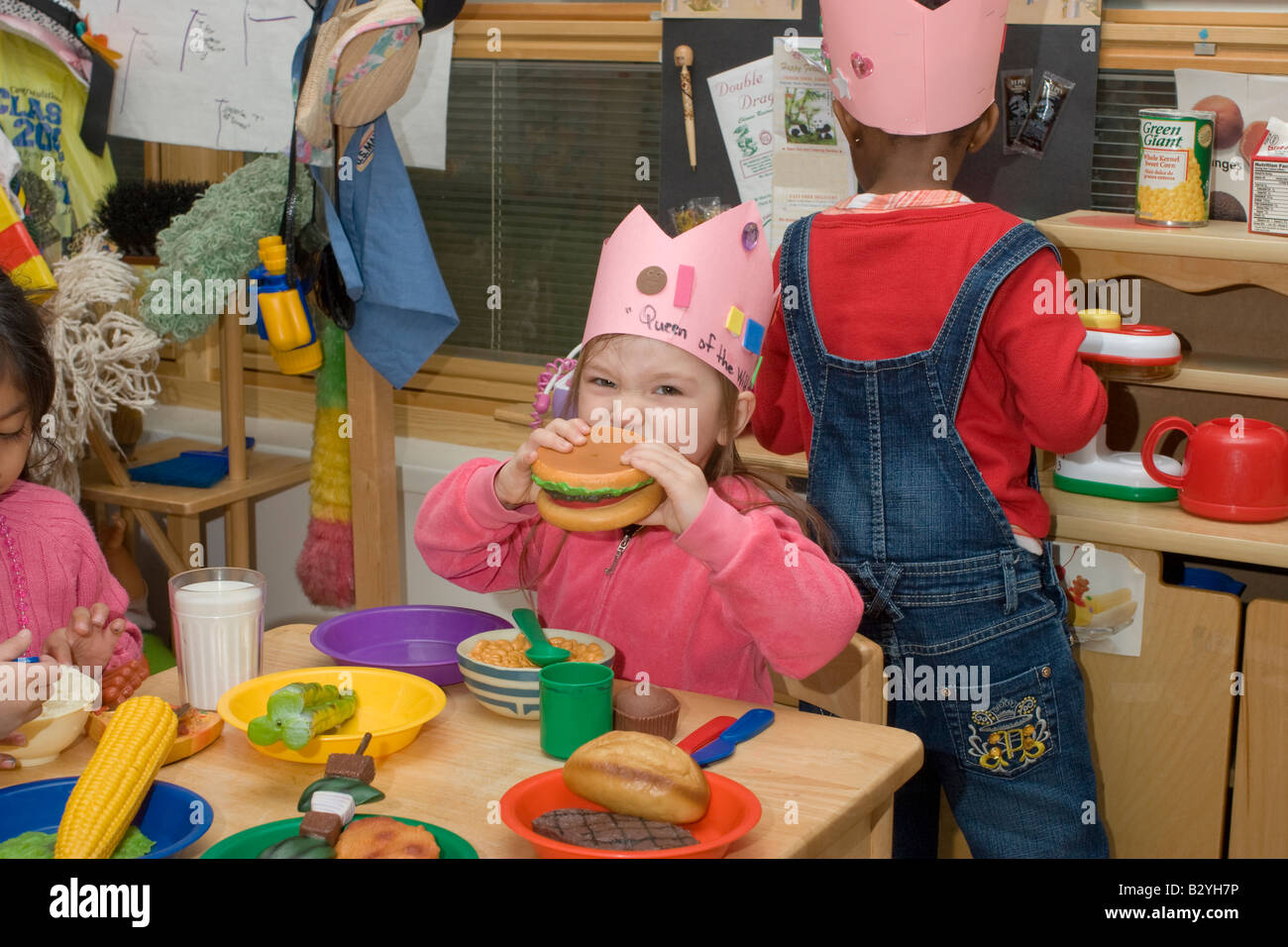 4 year old Caucasian preschool girl pretending it to eat a toy ...
