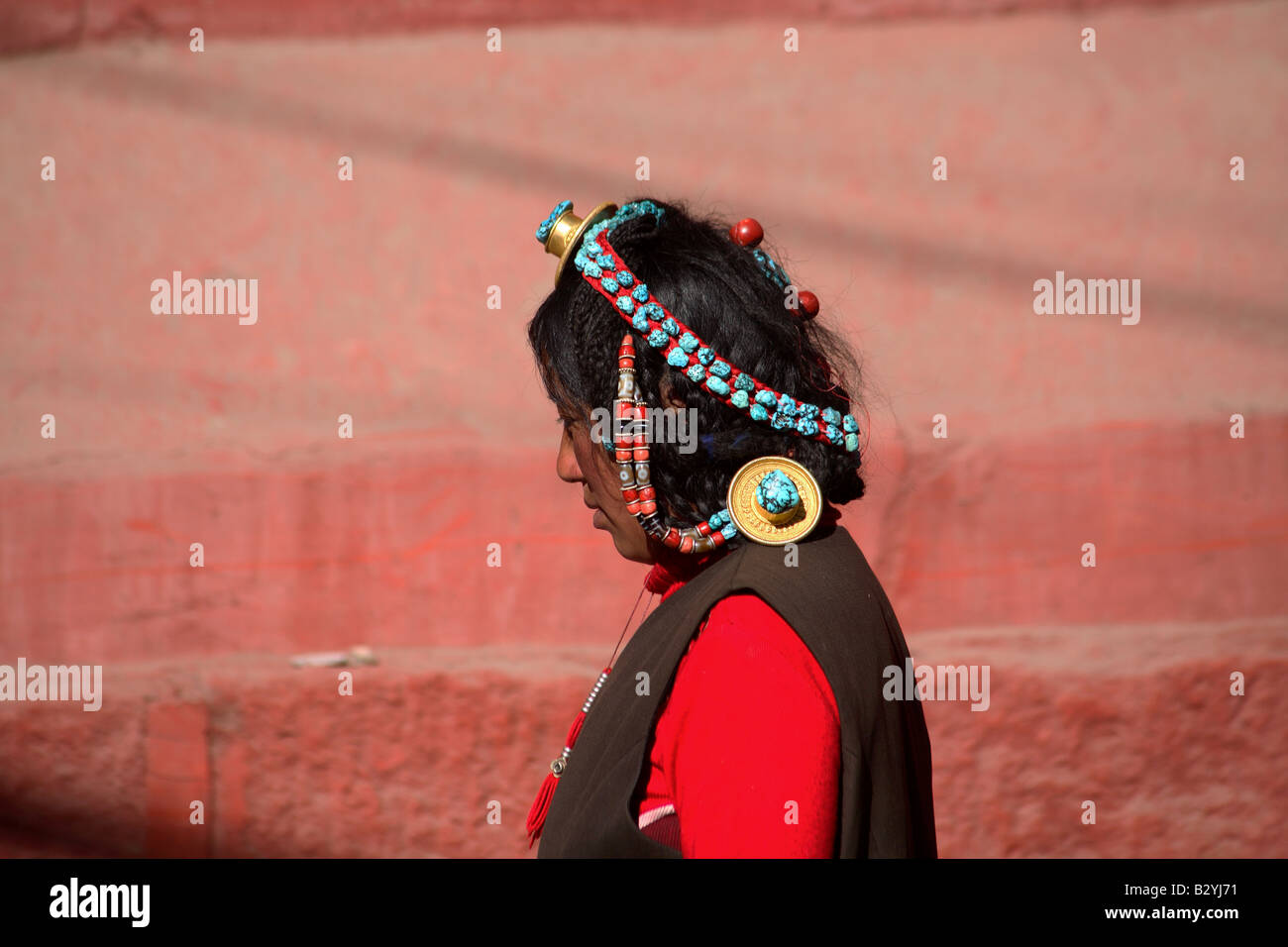 a Tibetan women encircles the monastery in Dege, Sichuan Province,China ...