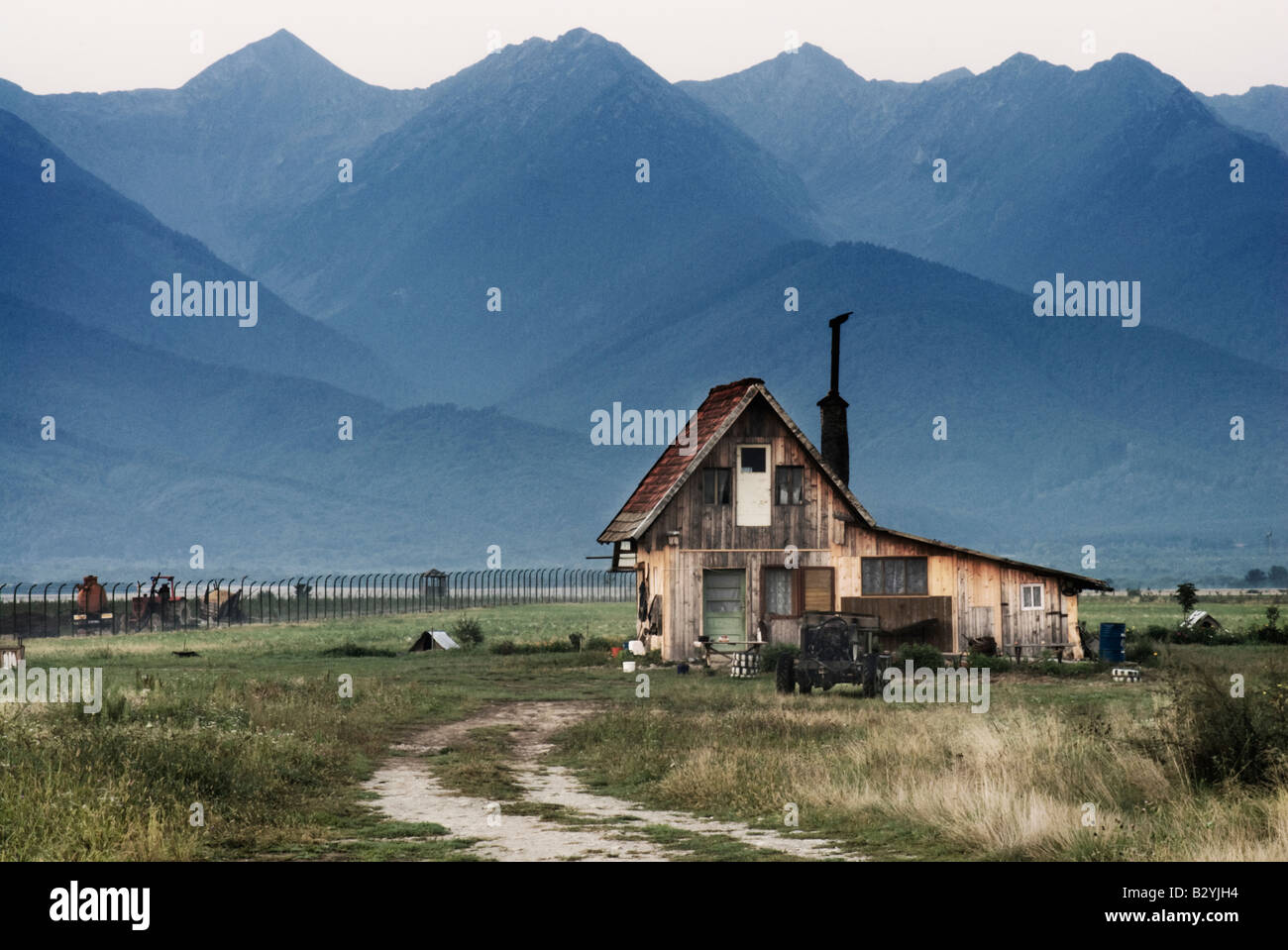 Farmhouse on the Brasov-Sibiu road, Romania. Fagaras mountains in the ...