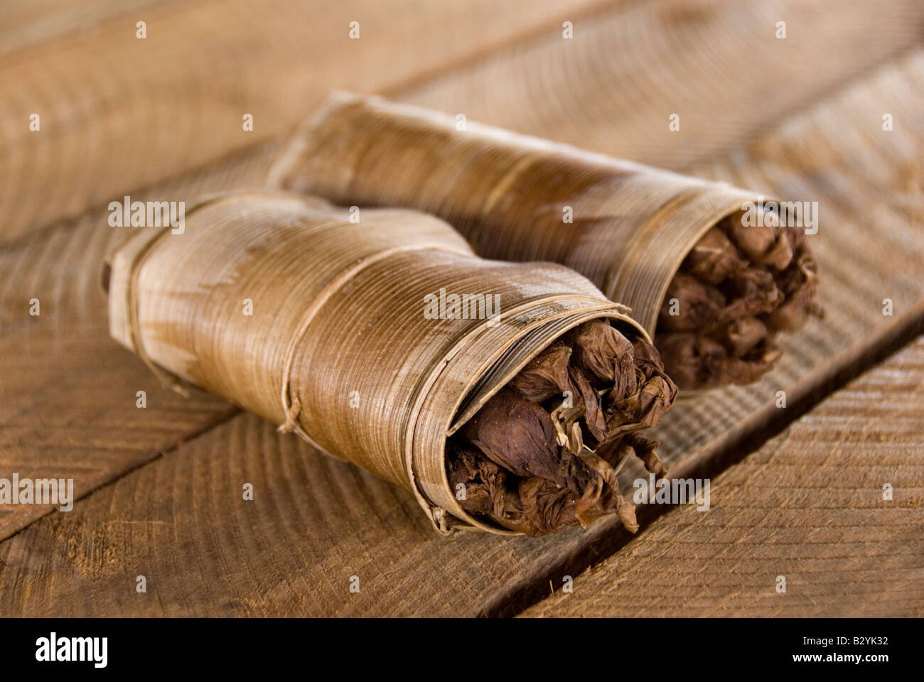 Home made and hand rolled Cuban cigars bundled together in a dried leaf ...