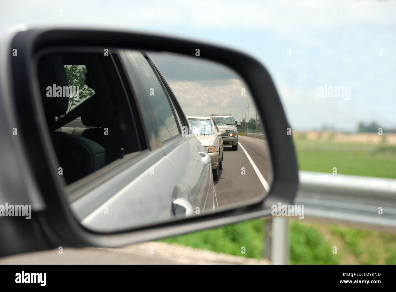 Rear view mirror reflecting a line of cars behind Stock Photo - Alamy