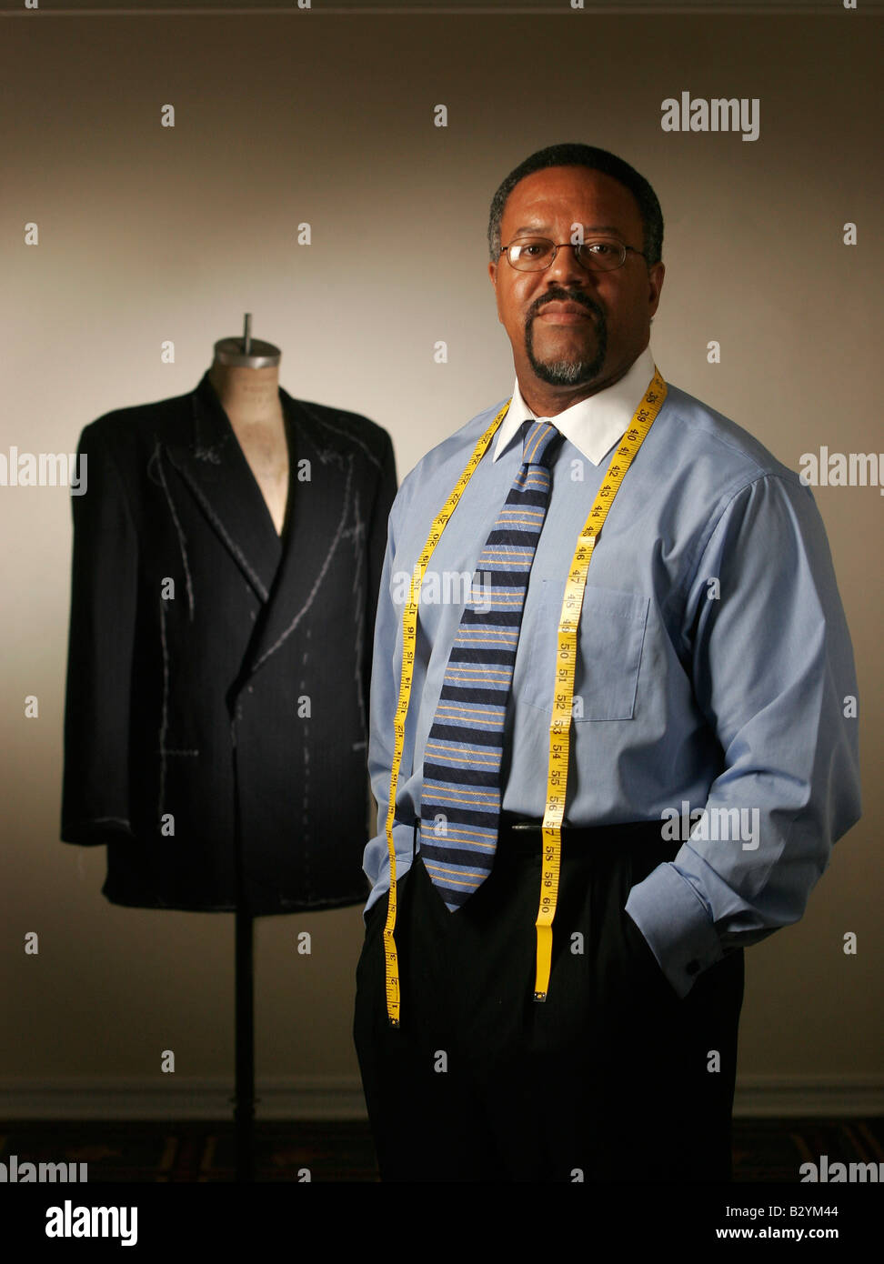 A professional tailor pictured with a tailor's dummy in his workshop ...