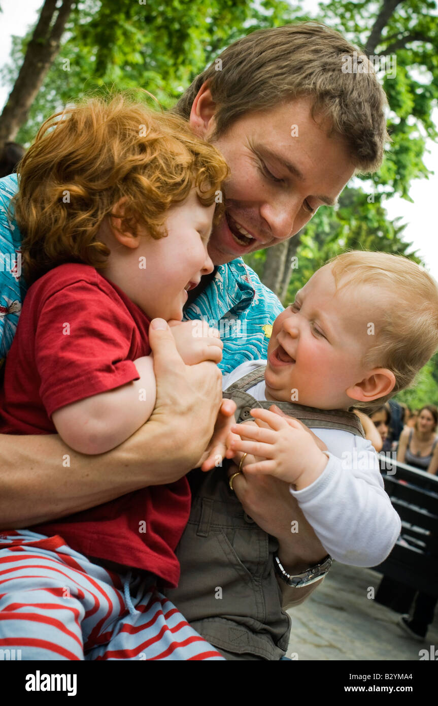 Father cuddling his two young sons Stock Photo - Alamy
