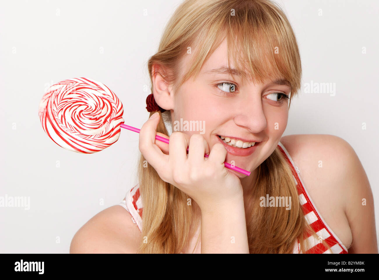 The girl with a sugar candy on a stick is emotional Stock Photo - Alamy