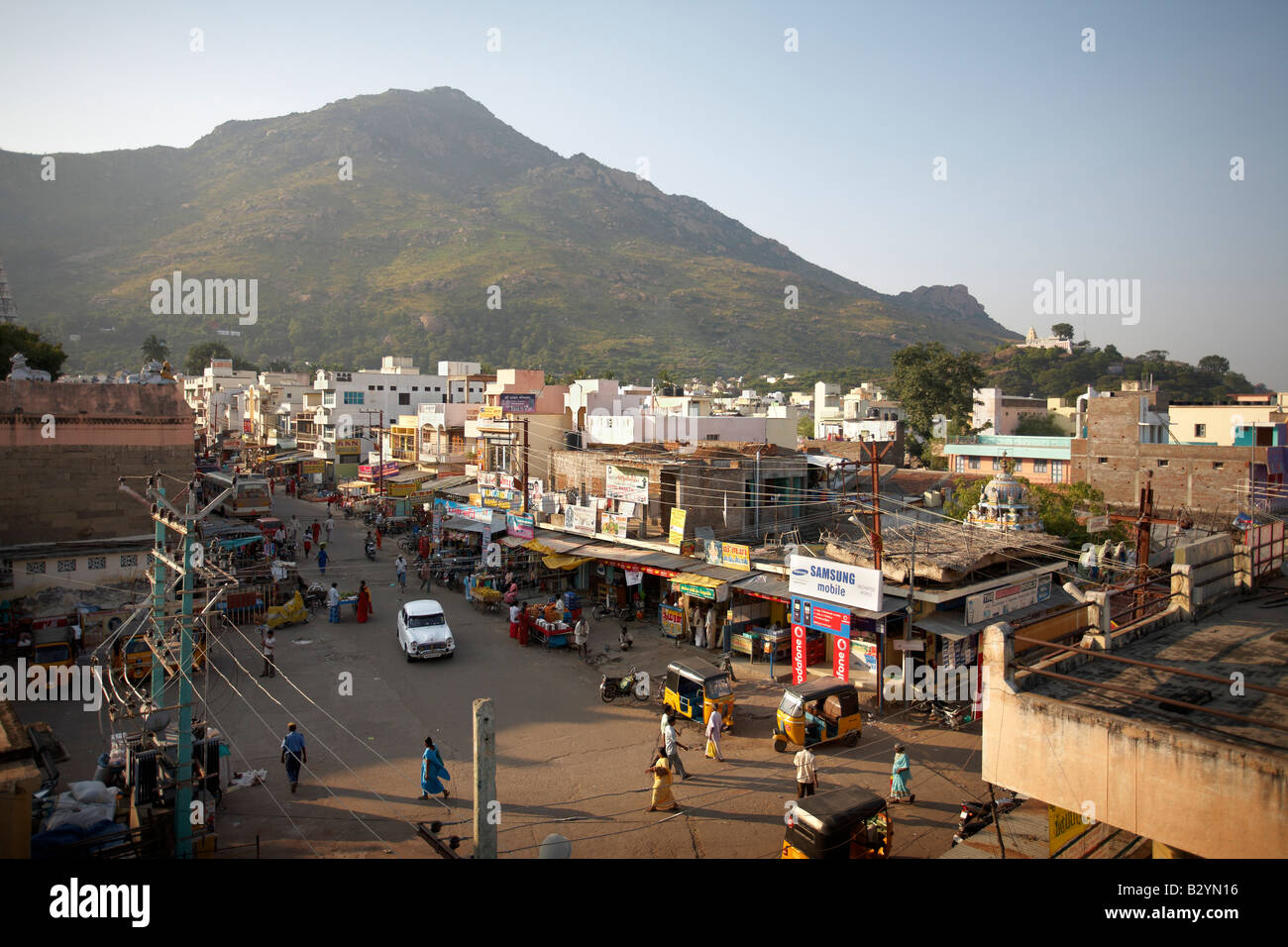 A view down the street of a small Indian town with a mountain on the ...
