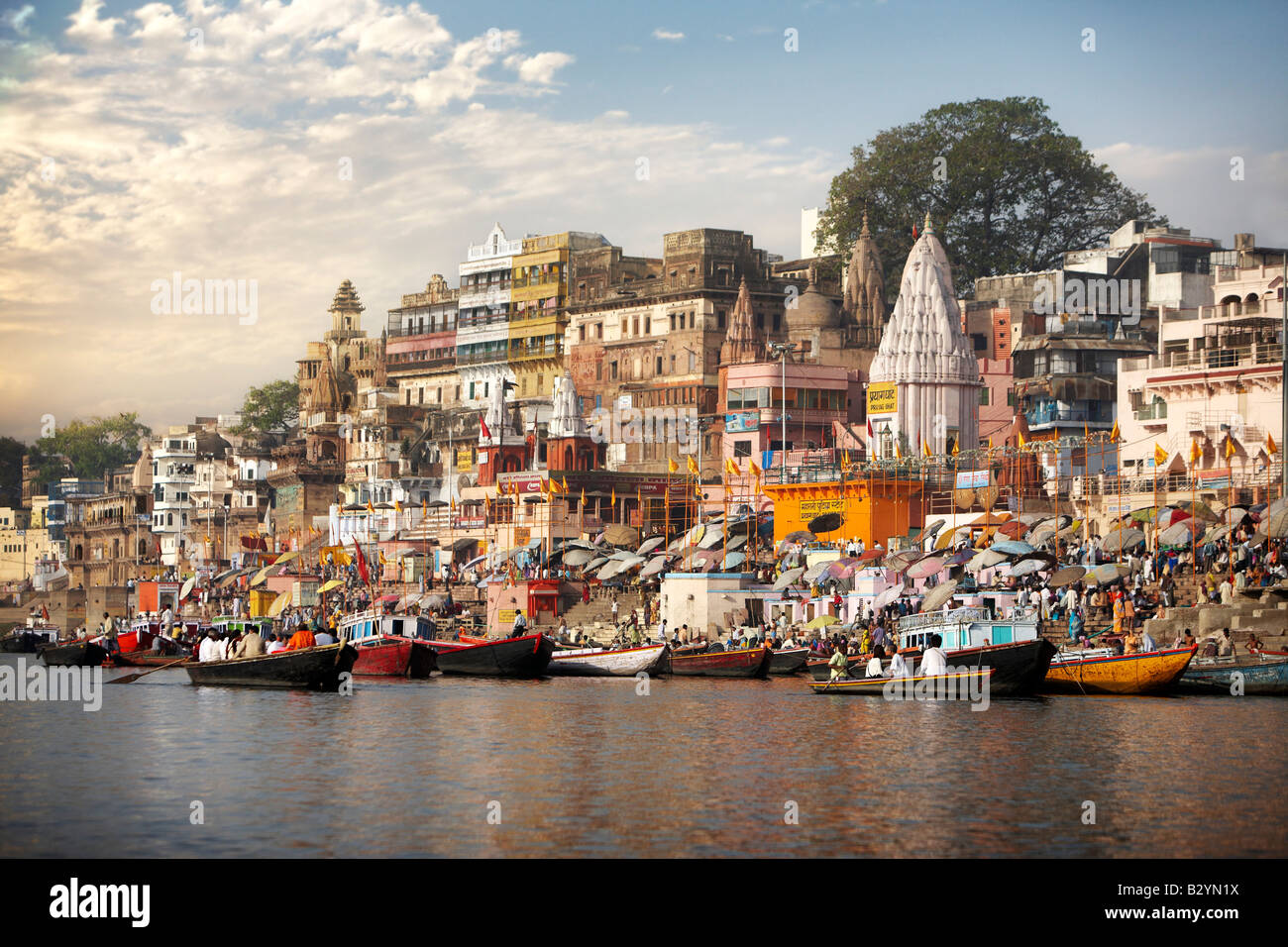 The Ganges River in the foreground with boats, temples and blue sky of ...