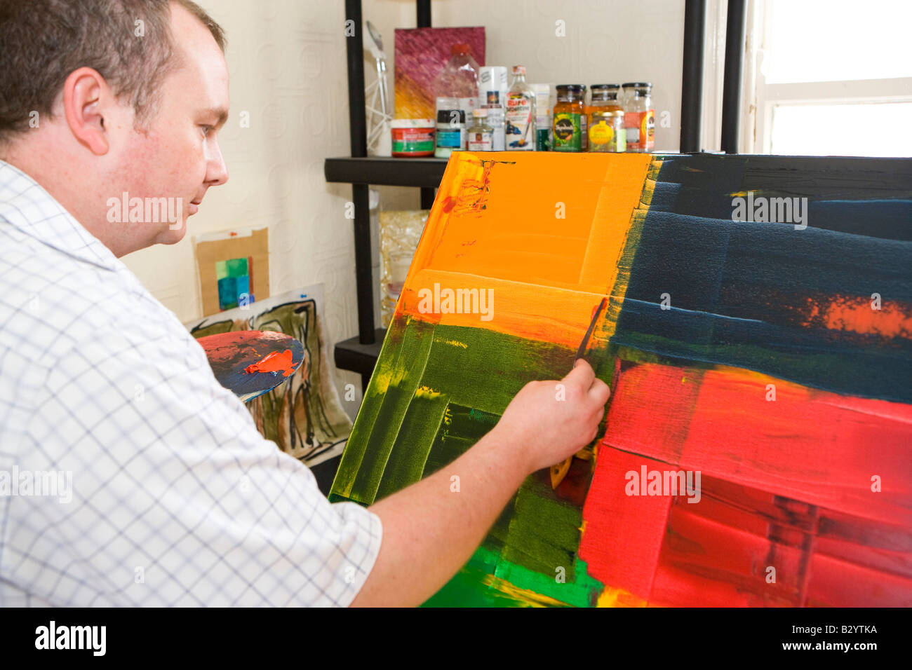 artist working on an abstract painting with a knife or trowel Stock ...