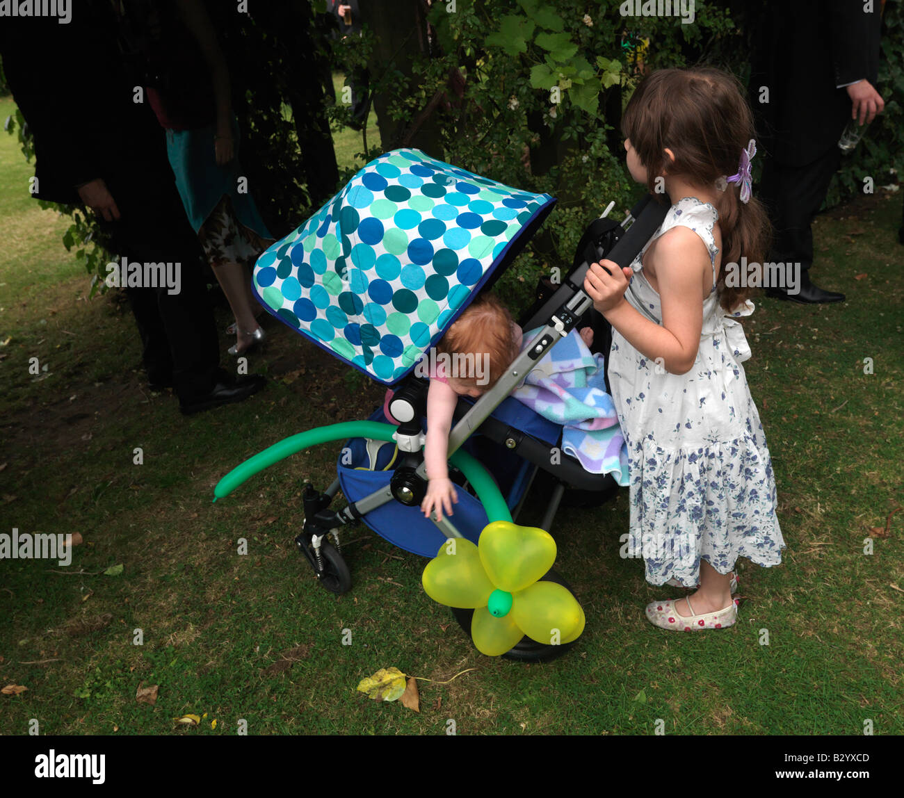 Children at a Wedding Reception Older Sister pushing younger Sibling in ...