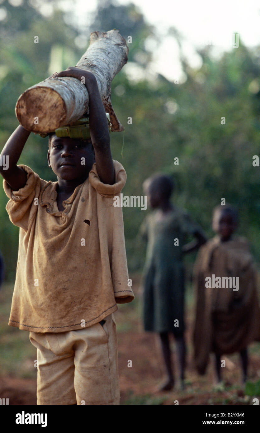 Young boy carrying log of wood on head, Burundi Stock Photo - Alamy