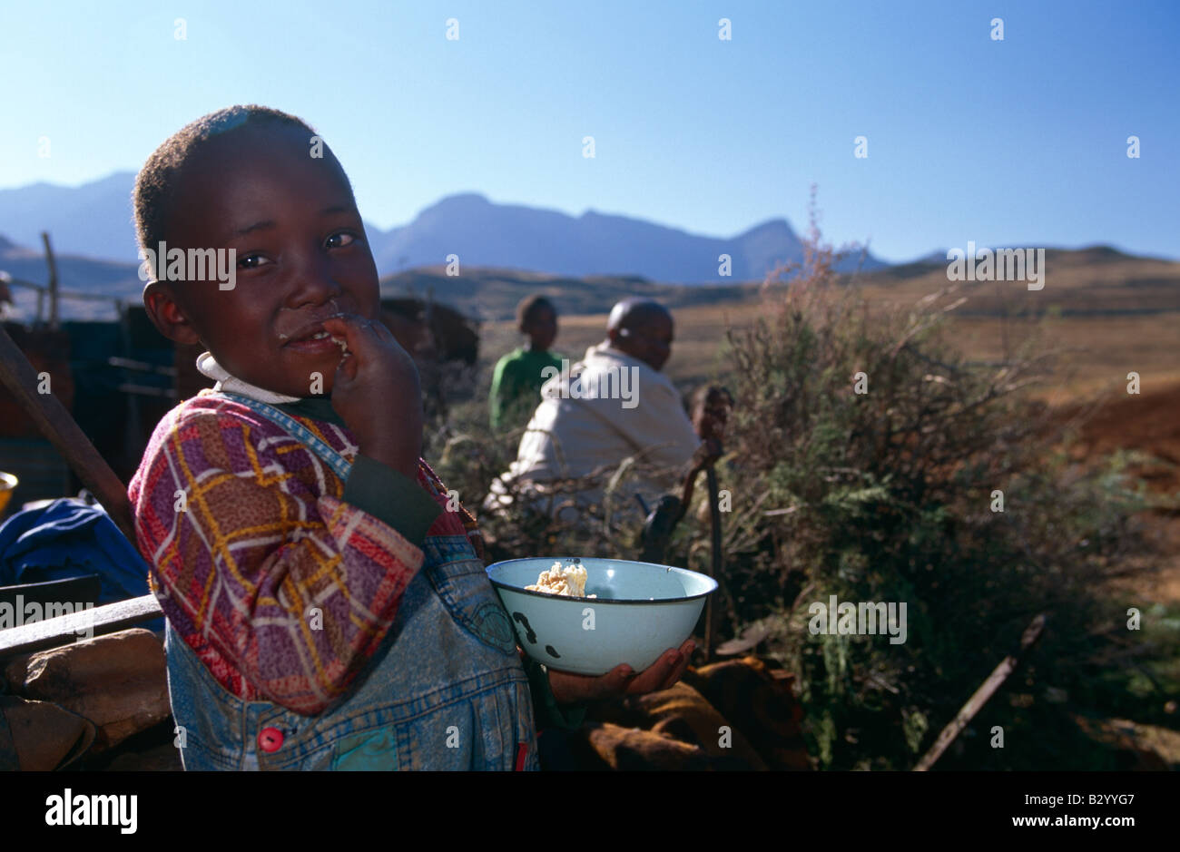 Boy eating bowl of food outside, portrait, Lesotho, Africa Stock Photo ...