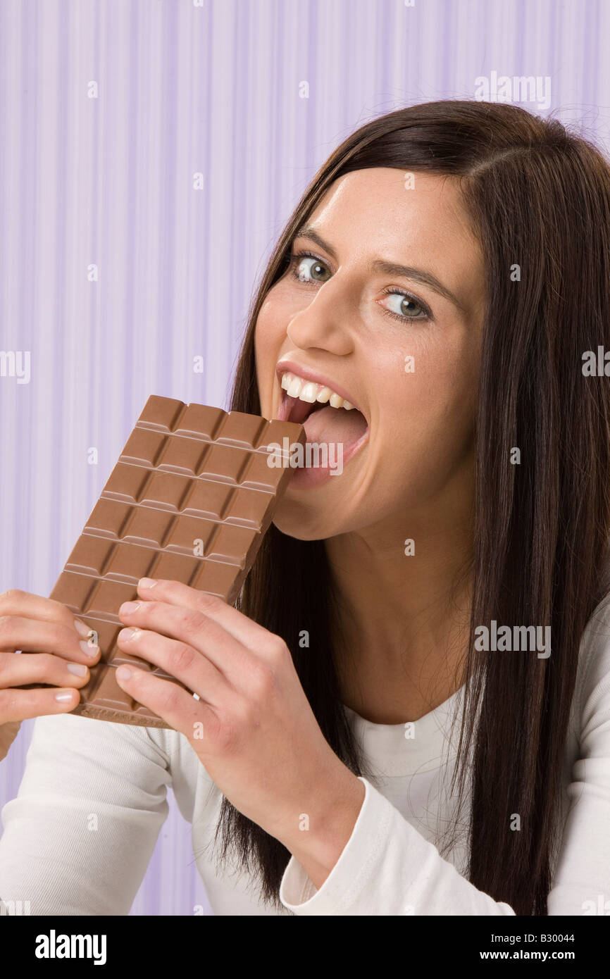 Woman Eating Chocolate Bar Stock Photo - Alamy
