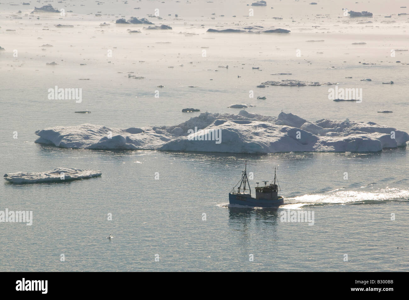 An Inuit fishing boat sails through Icebergs from the Jacobshavn ...