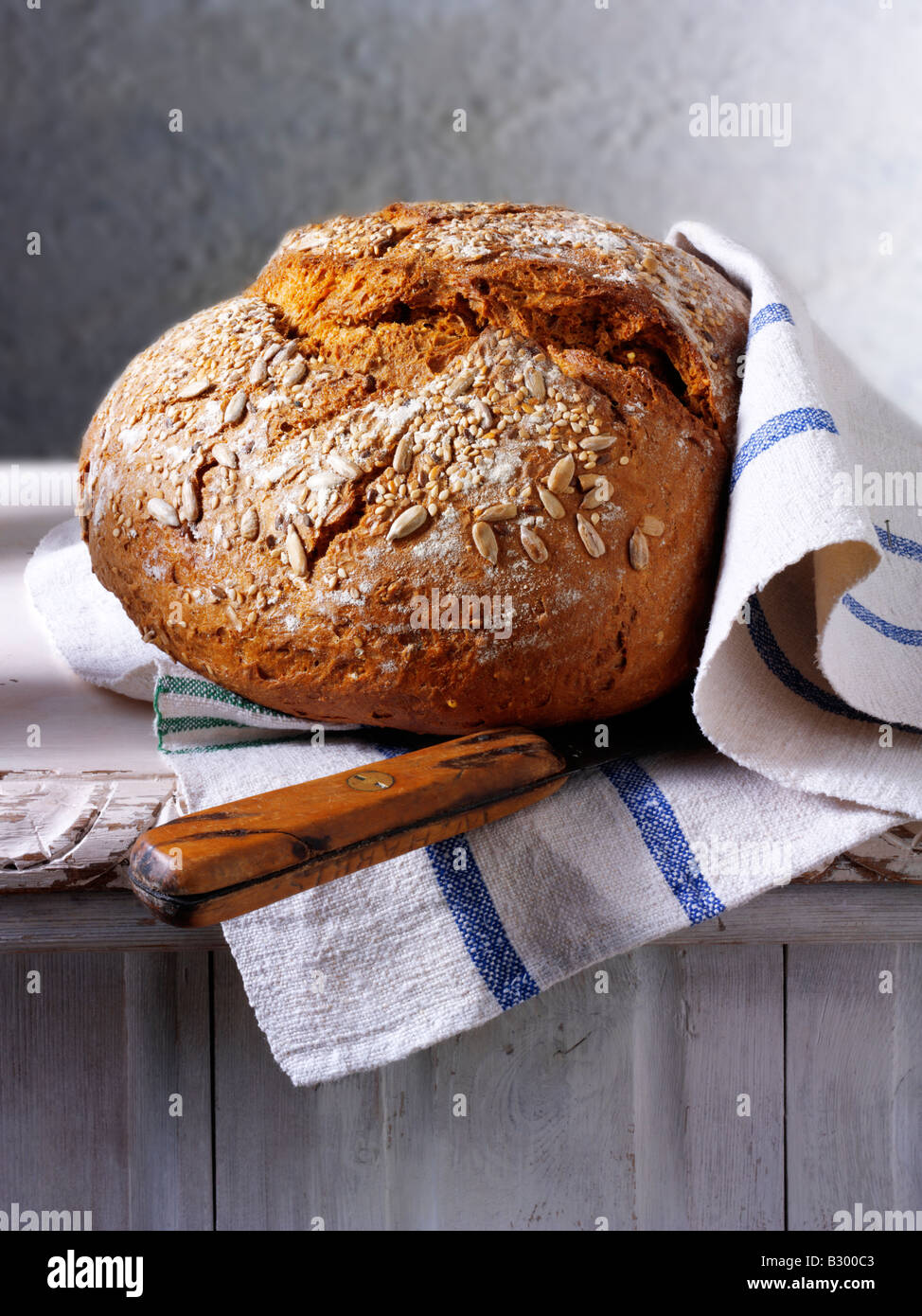 loaf of artedab sour dough wholemeal bread in a rustic setting on a wood table Stock Photo - Alamy