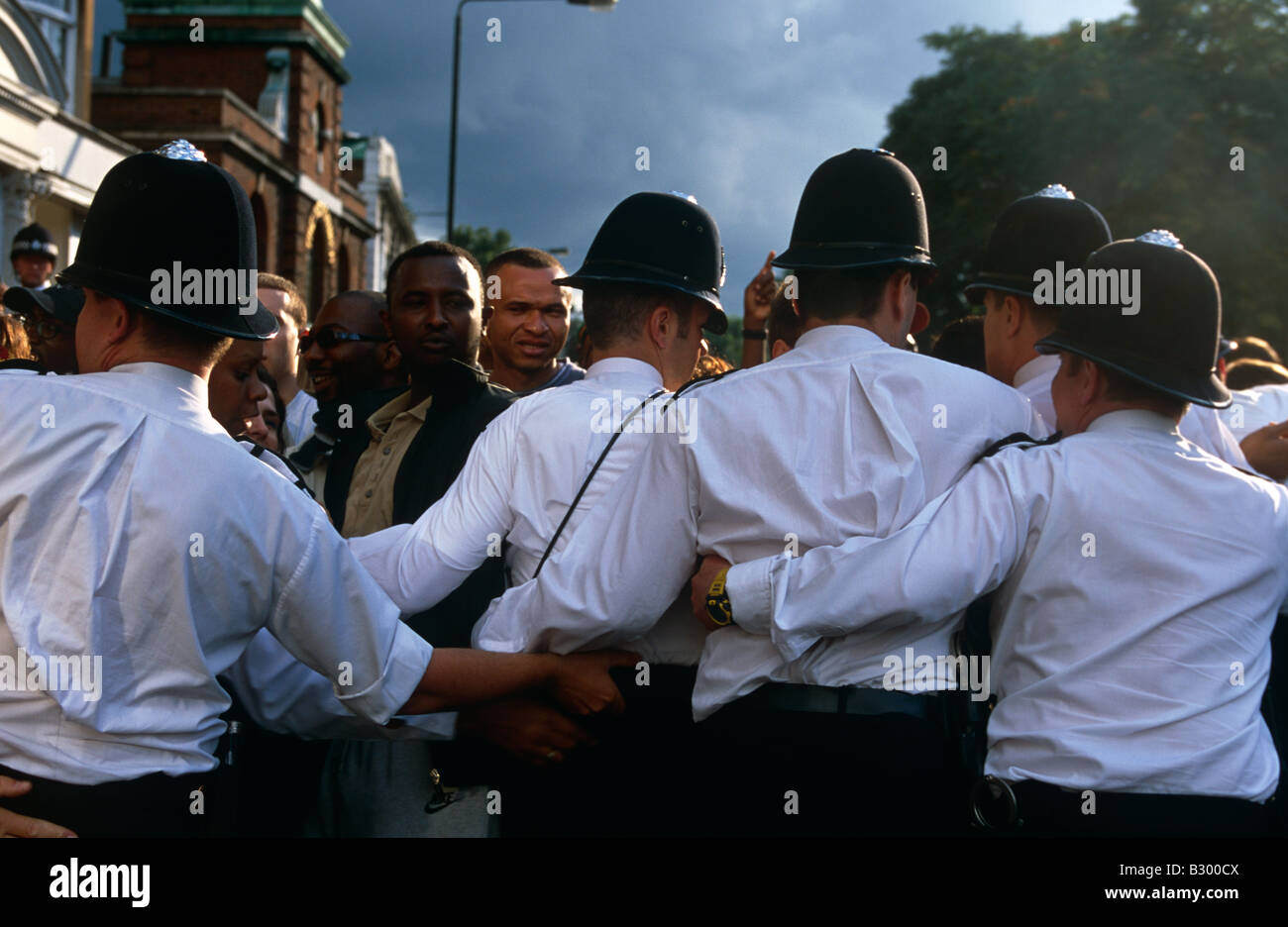 Police team face to face with crowd at carnival, rear view, London, UK ...