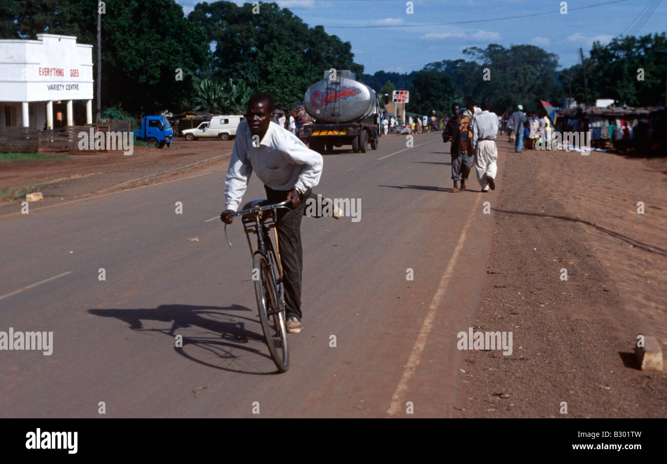 Man pushing off on bicycle on road. Malawi, Mozambique Stock Photo - Alamy