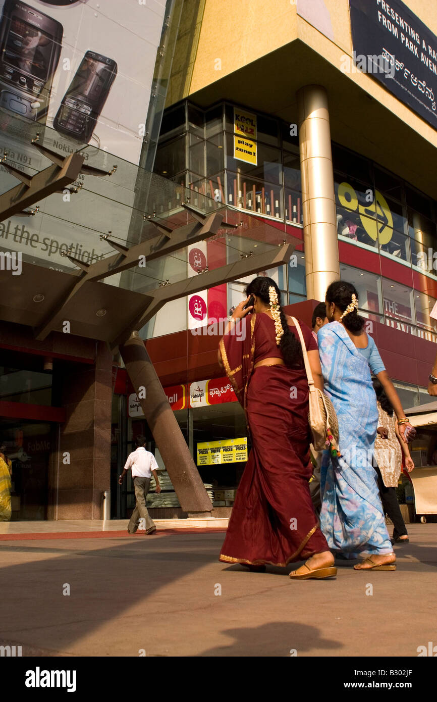 Two women walk toward the entrance to a shopping mall in Bangalore ...