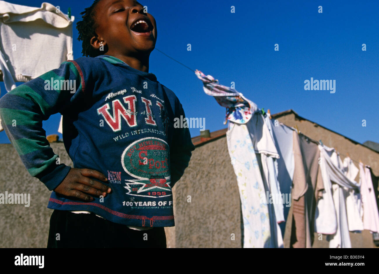 Girl next to washing line laughing, low angle view, Johannesburg, South ...