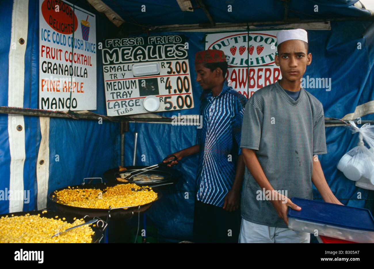 Stall holders frying sweetcorn on street market food stall, South ...