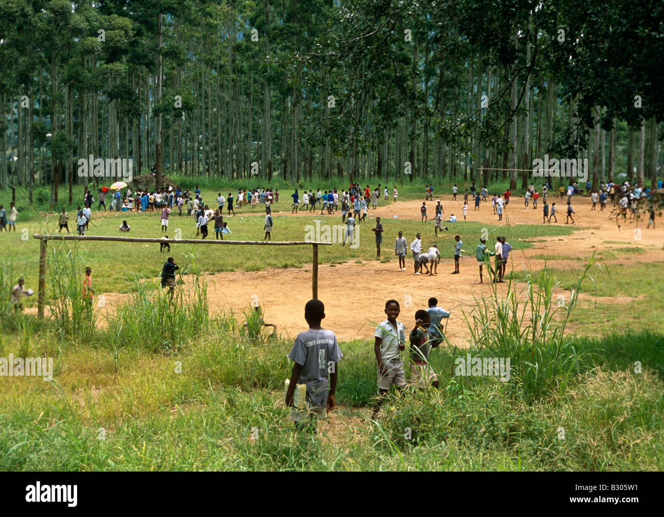 Crowds of schoolchildren playing on school playing field in rural ...