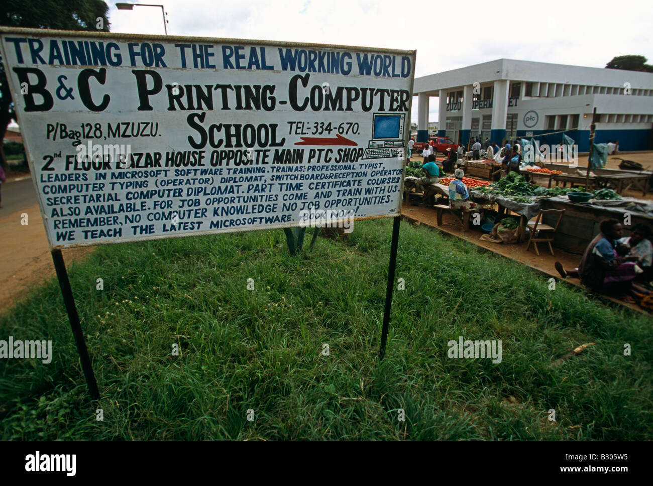 Sign for computer school in grassy corner of street market. Uganda ...