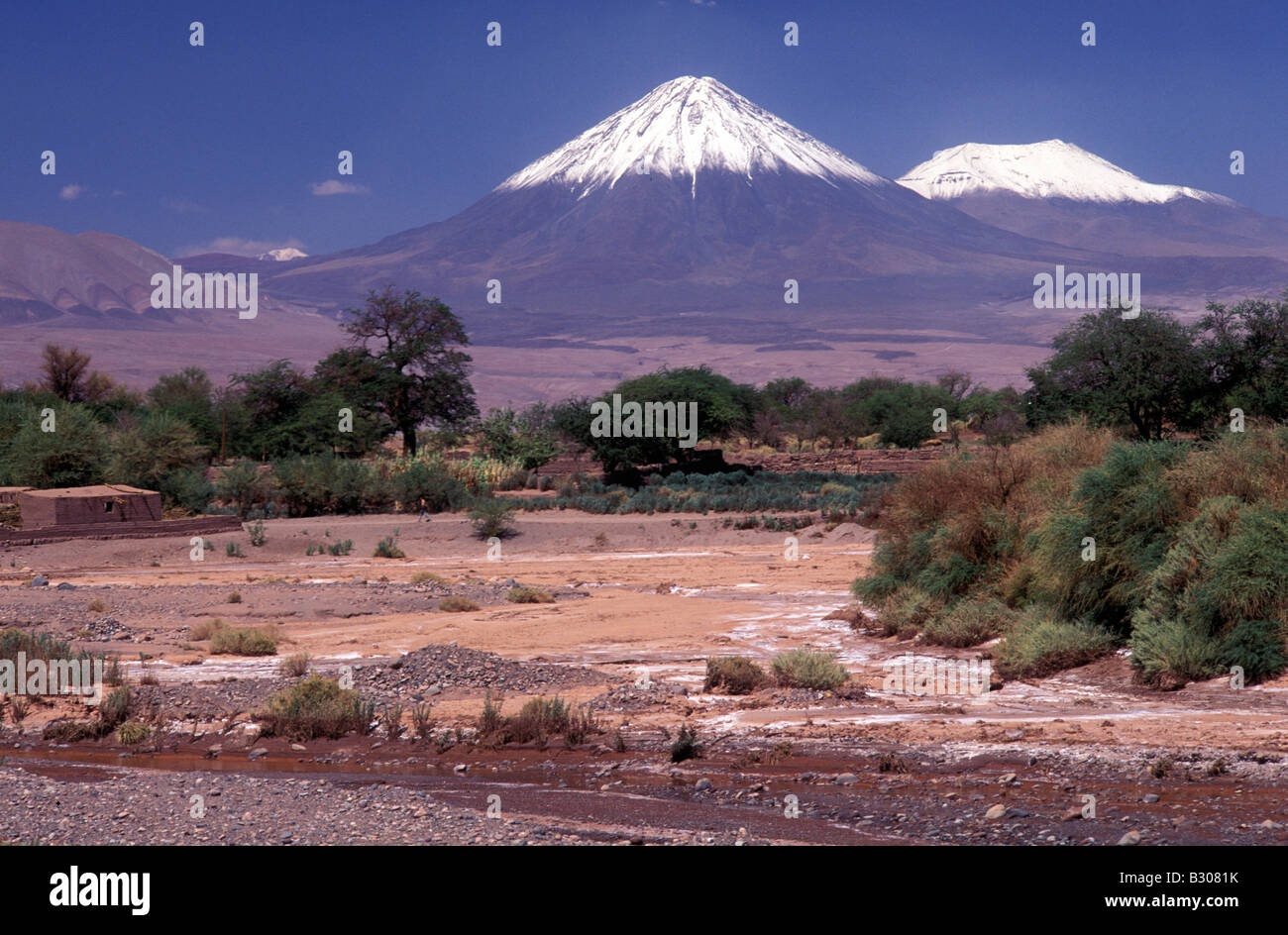 Snow capped volcanoes mark the border between Chile and Bolivia seen ...
