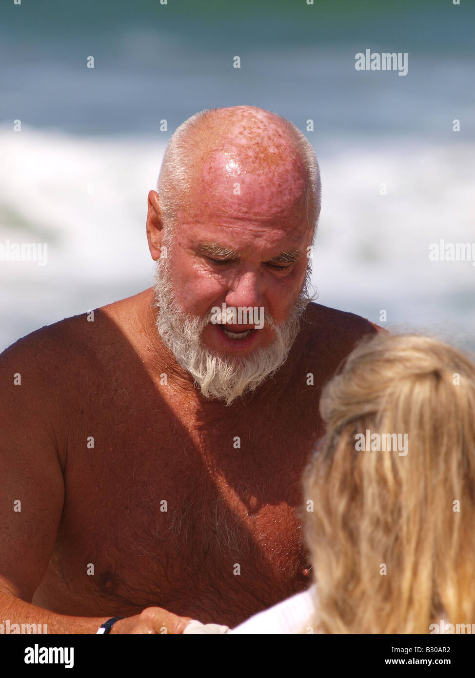 Senior lifeguard competitor talks to young woman Stock Photo - Alamy