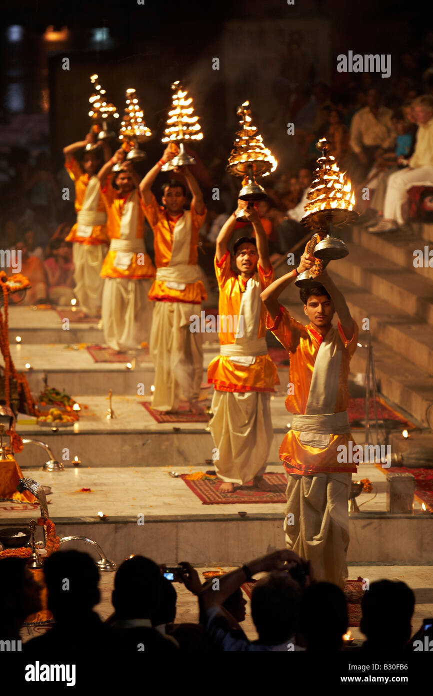 A line of Indian priests perform a candle light ceremony before a crowd ...