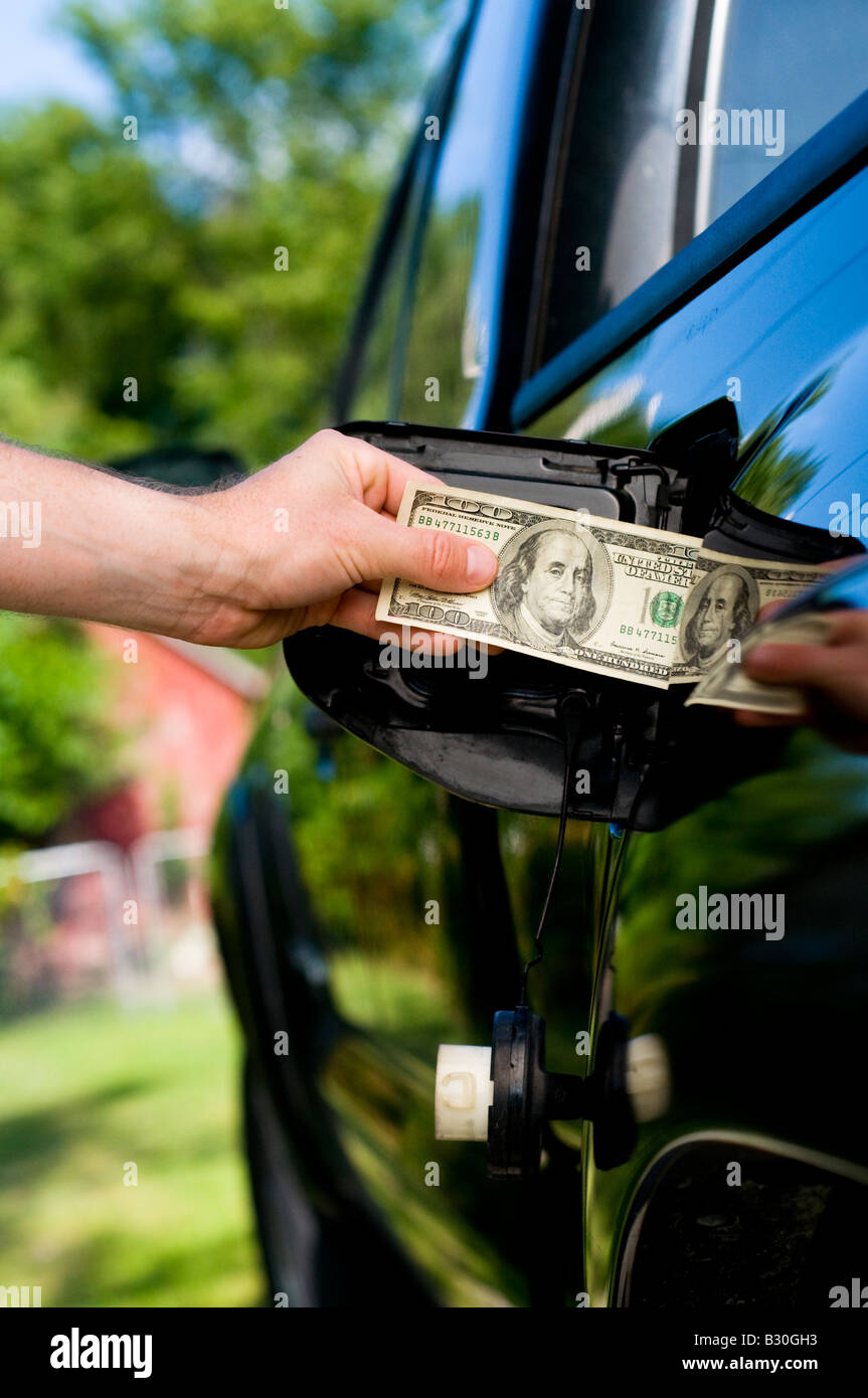 putting money in fuel tank Stock Photo - Alamy