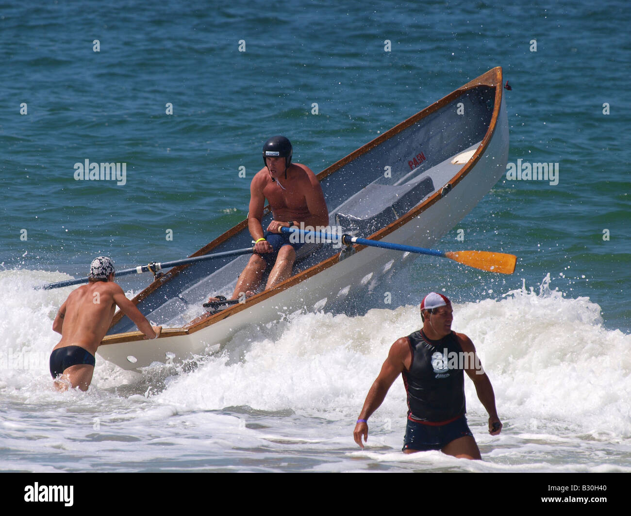 Competitor gets an assist rowing surf boat through the waves at the ...