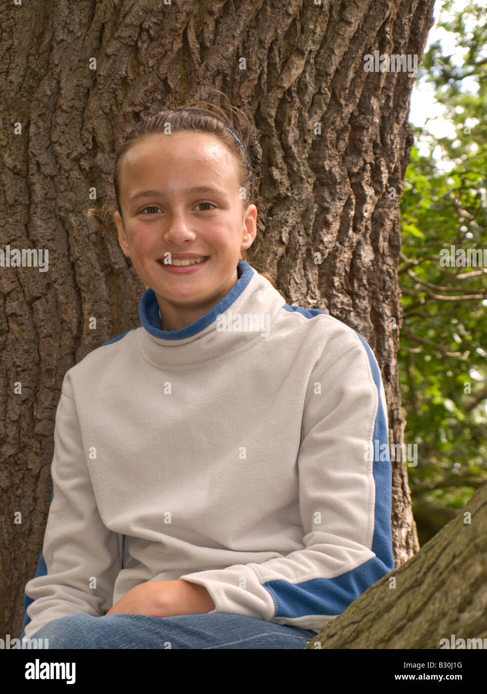 Girl sitting in a tree Stock Photo - Alamy