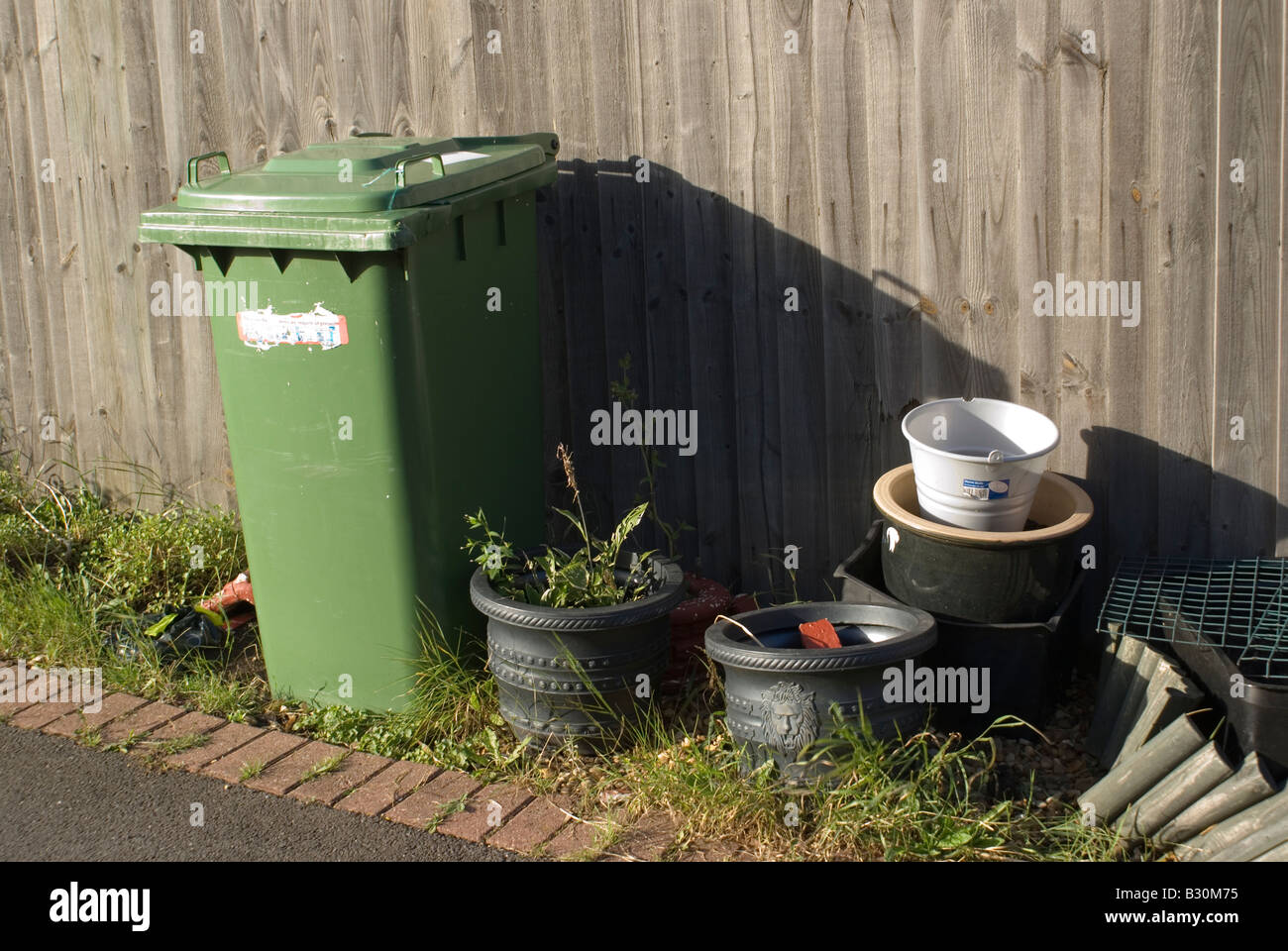 Recycling bin against fence with garden waste Stock Photo - Alamy
