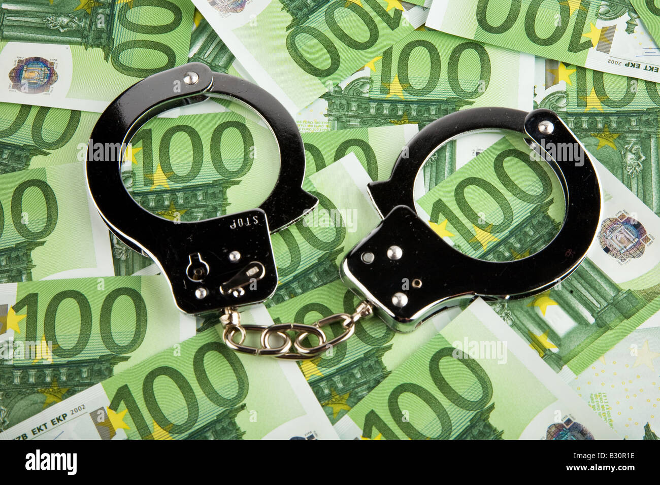 Euro bank notes and handcuffs Stock Photo - Alamy