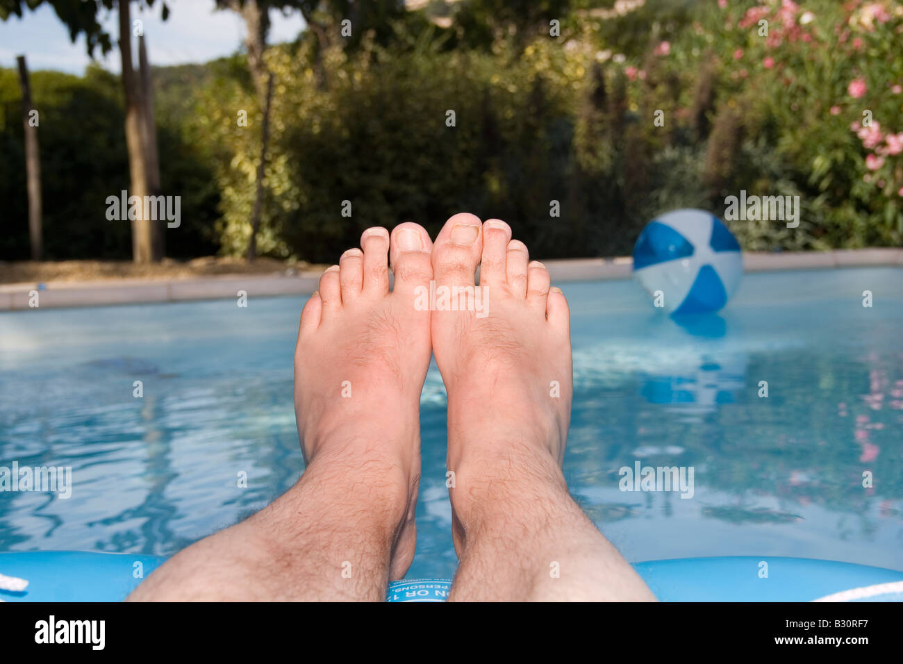 feet in boat in swimming pool with inflatable beach ball Stock Photo ...