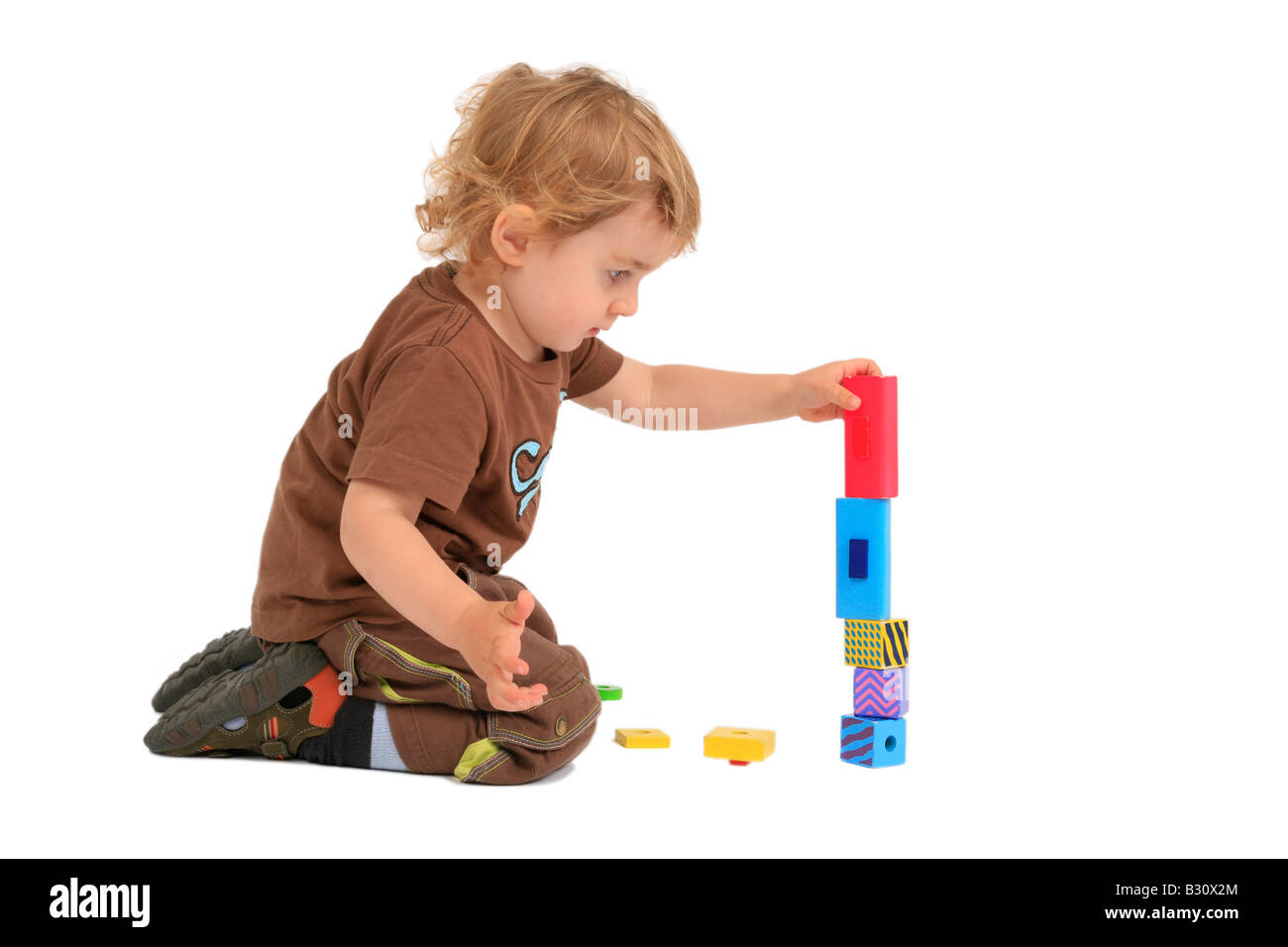 small boy builds brick tower Stock Photo - Alamy