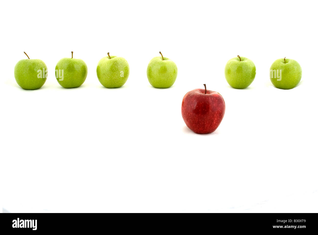 A line of green apples and one red apple Stock Photo - Alamy