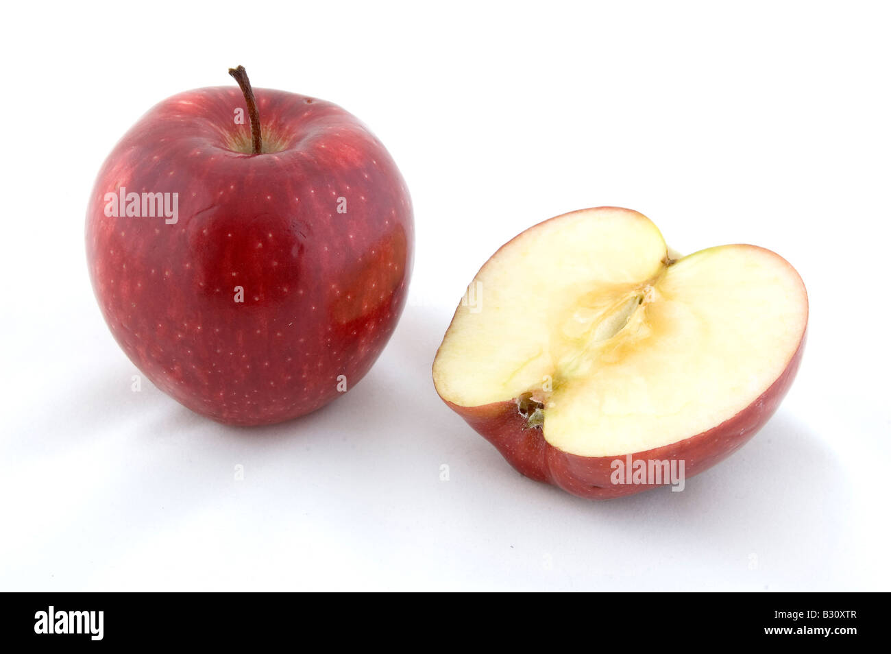 A red apple next to half an apple Stock Photo - Alamy
