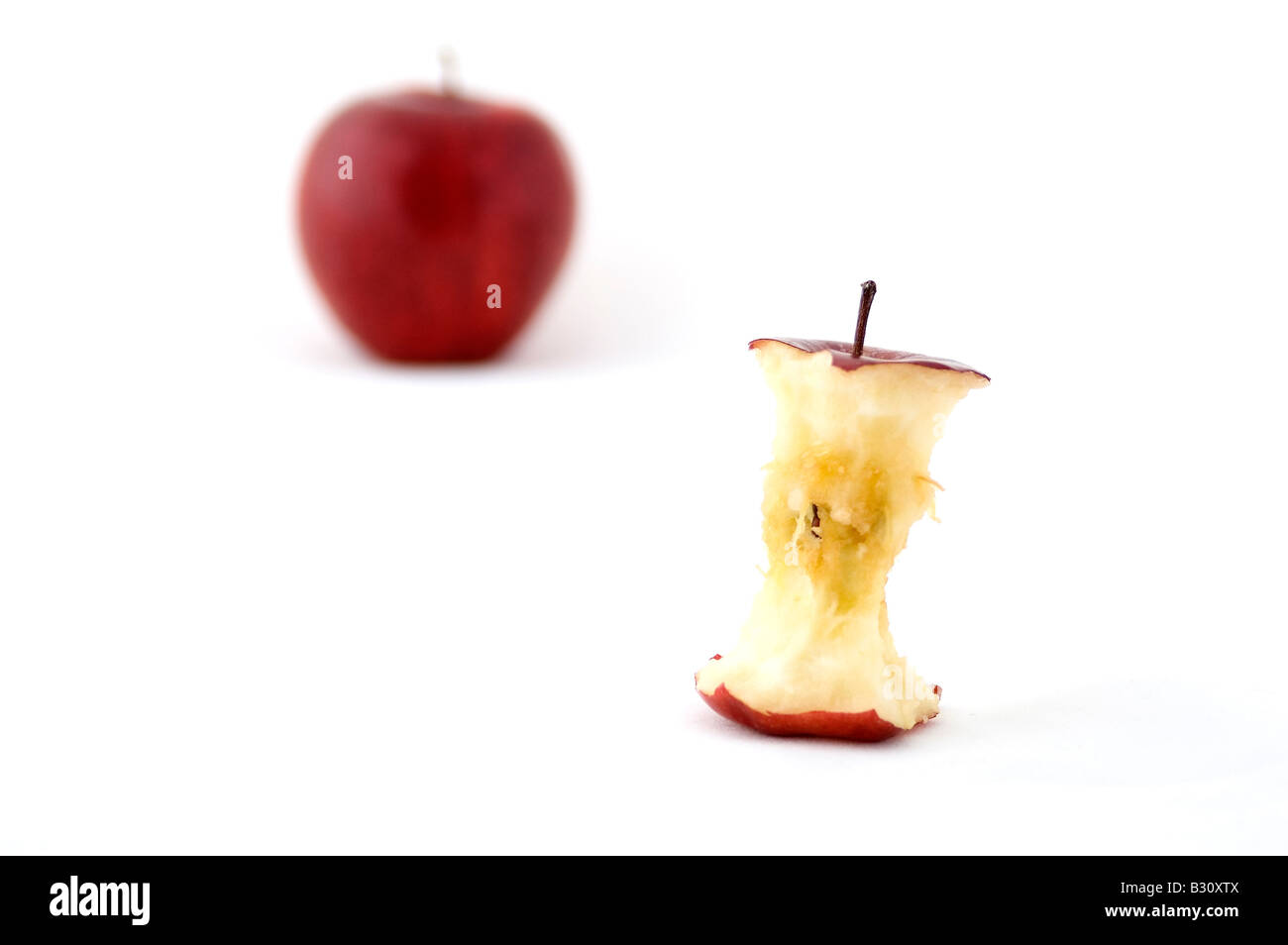 An apple core with an out of focus apple in the background Stock Photo ...