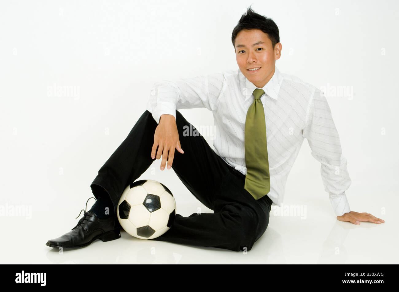 A young trendy businessman sitting with his ball Stock Photo - Alamy